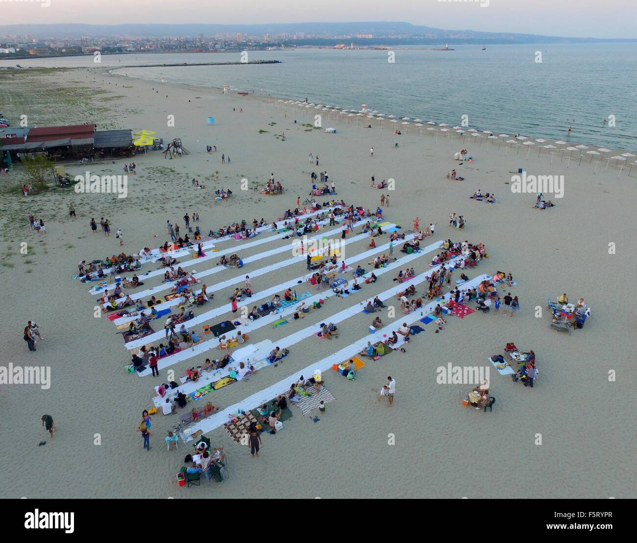 Thousands of people bring their dinner to an improvised table on ...
