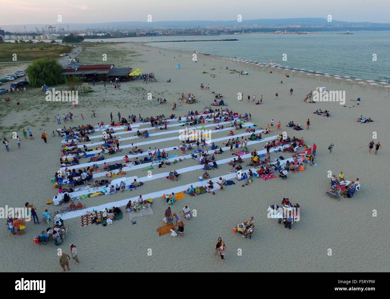 Thousands of people bring their dinner to an improvised table on ...