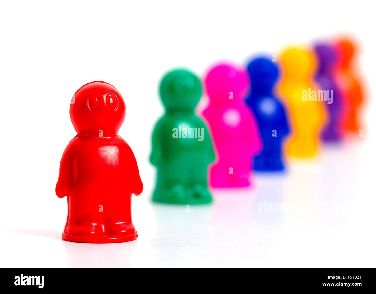 Colorful toy people group in queue on white background Stock Photo - Alamy