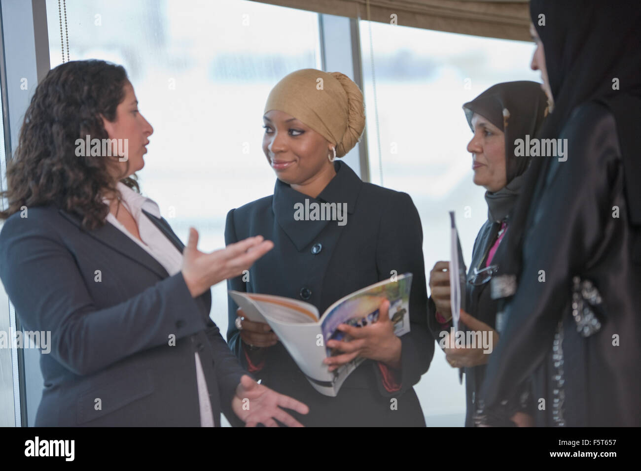 Muslim Women students discussing chatting in office environment Stock ...