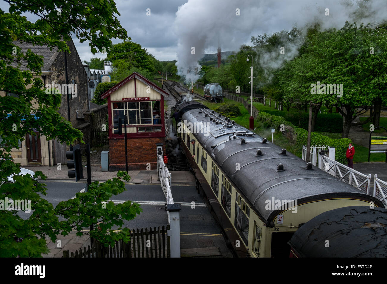 A steam train leaving the station, and passing the signal box, viewed ...