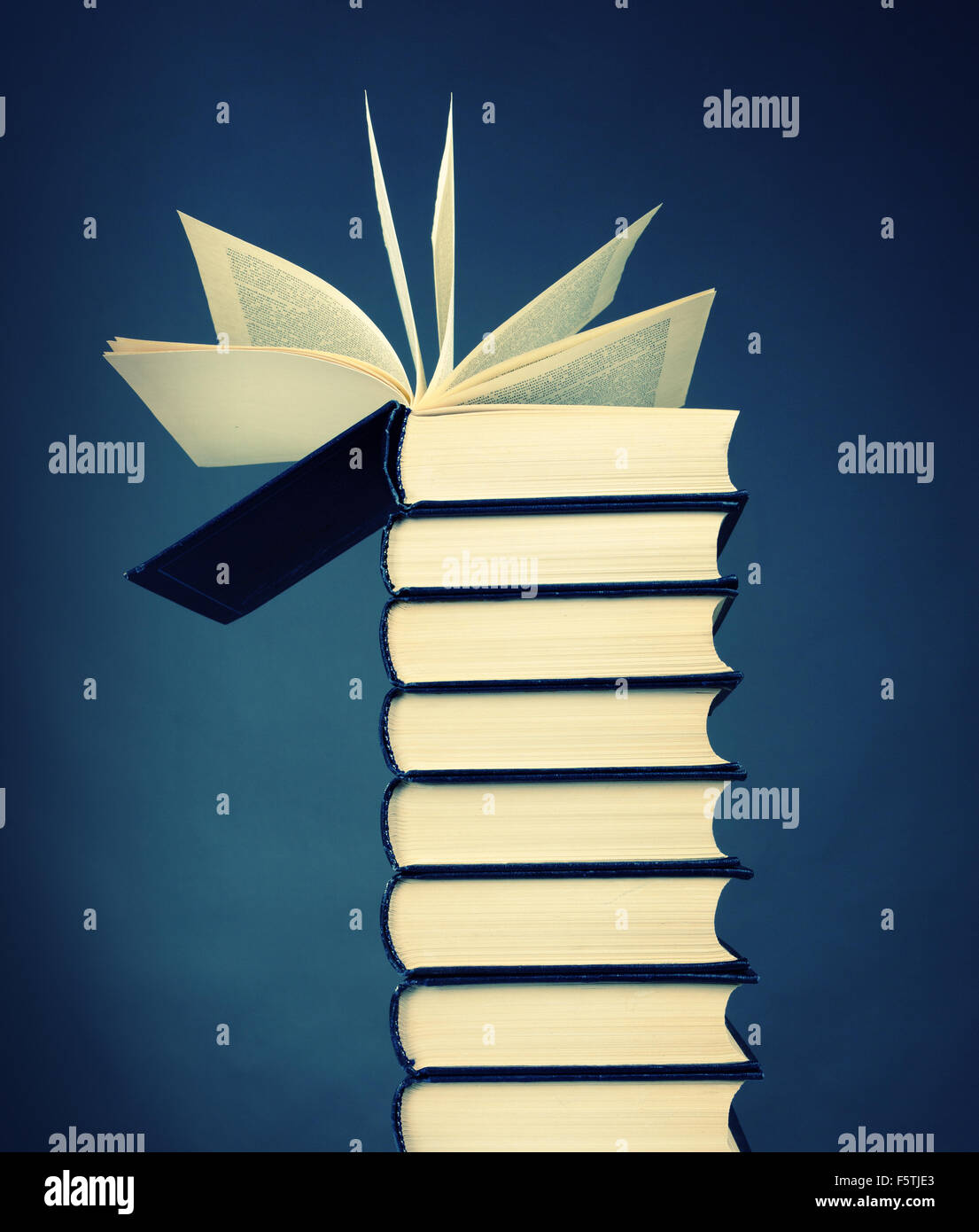 Stack of books with open book on top Stock Photo - Alamy