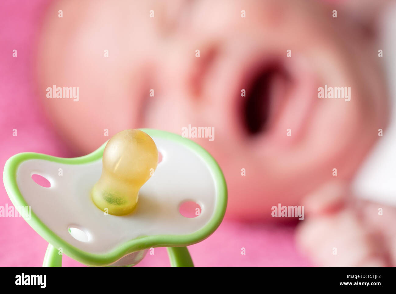 Close-up of pacifier with crying baby on background Stock Photo - Alamy