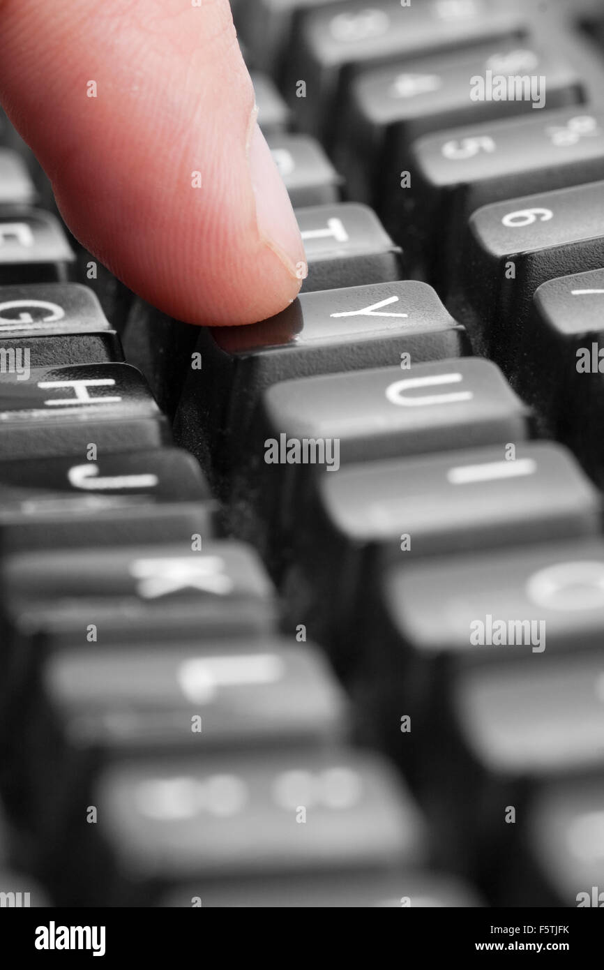 Close-up view of finger pressing "Y" key Stock Photo - Alamy