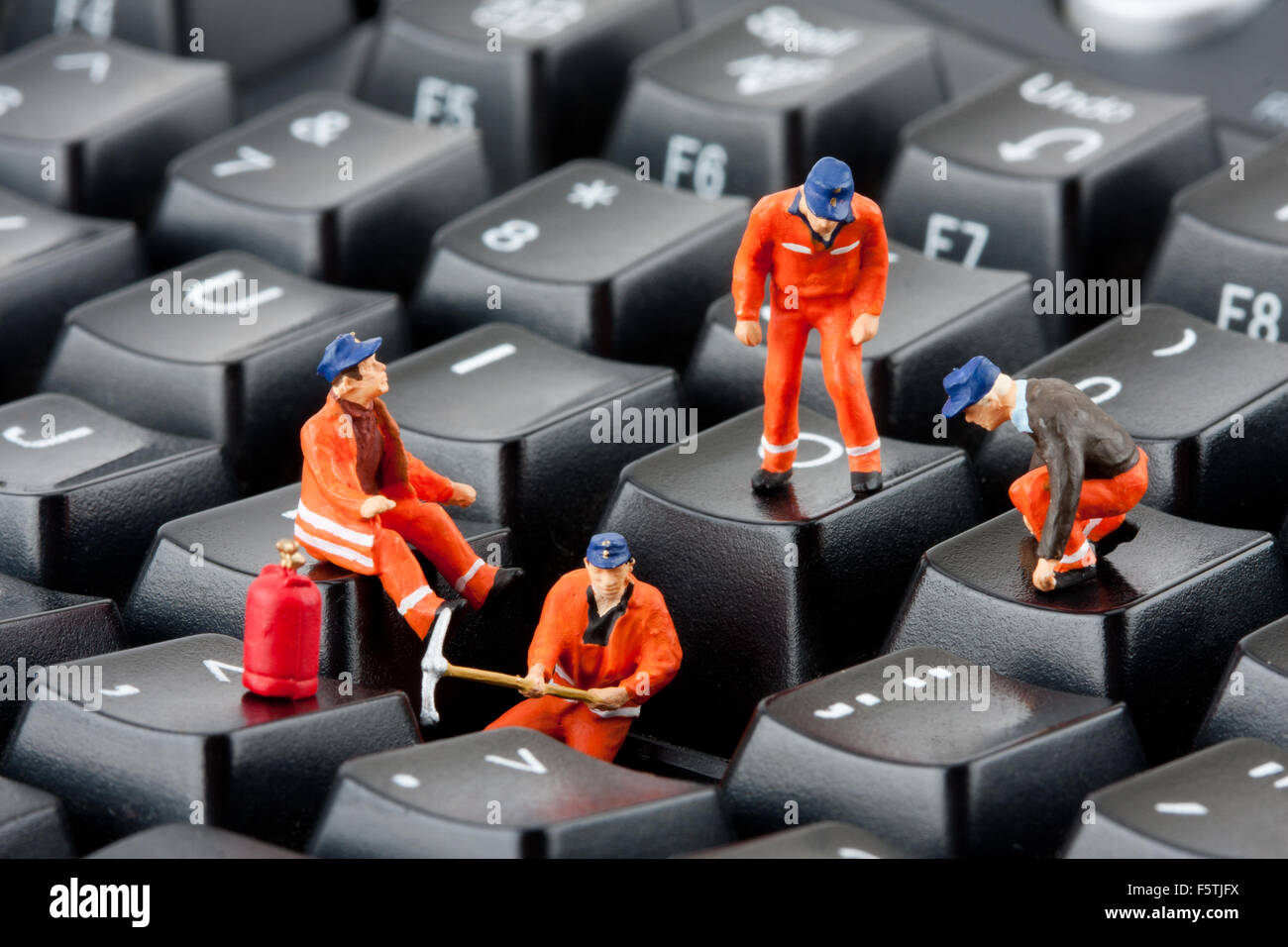 Small figurines of workers repairing computer keyboard Stock Photo - Alamy