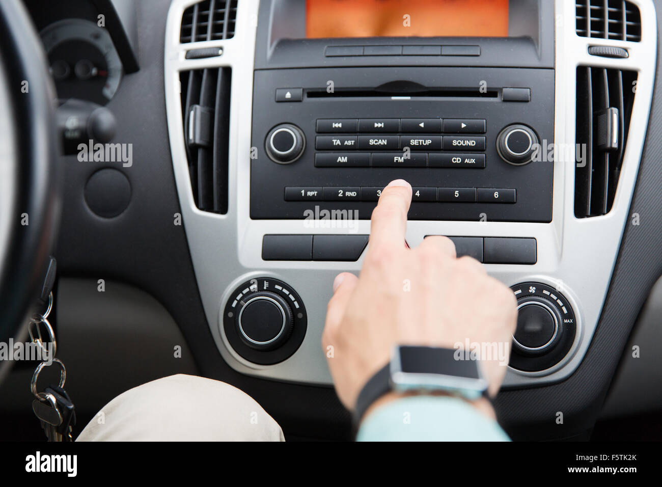 close up of male hand turning on radio in car Stock Photo - Alamy