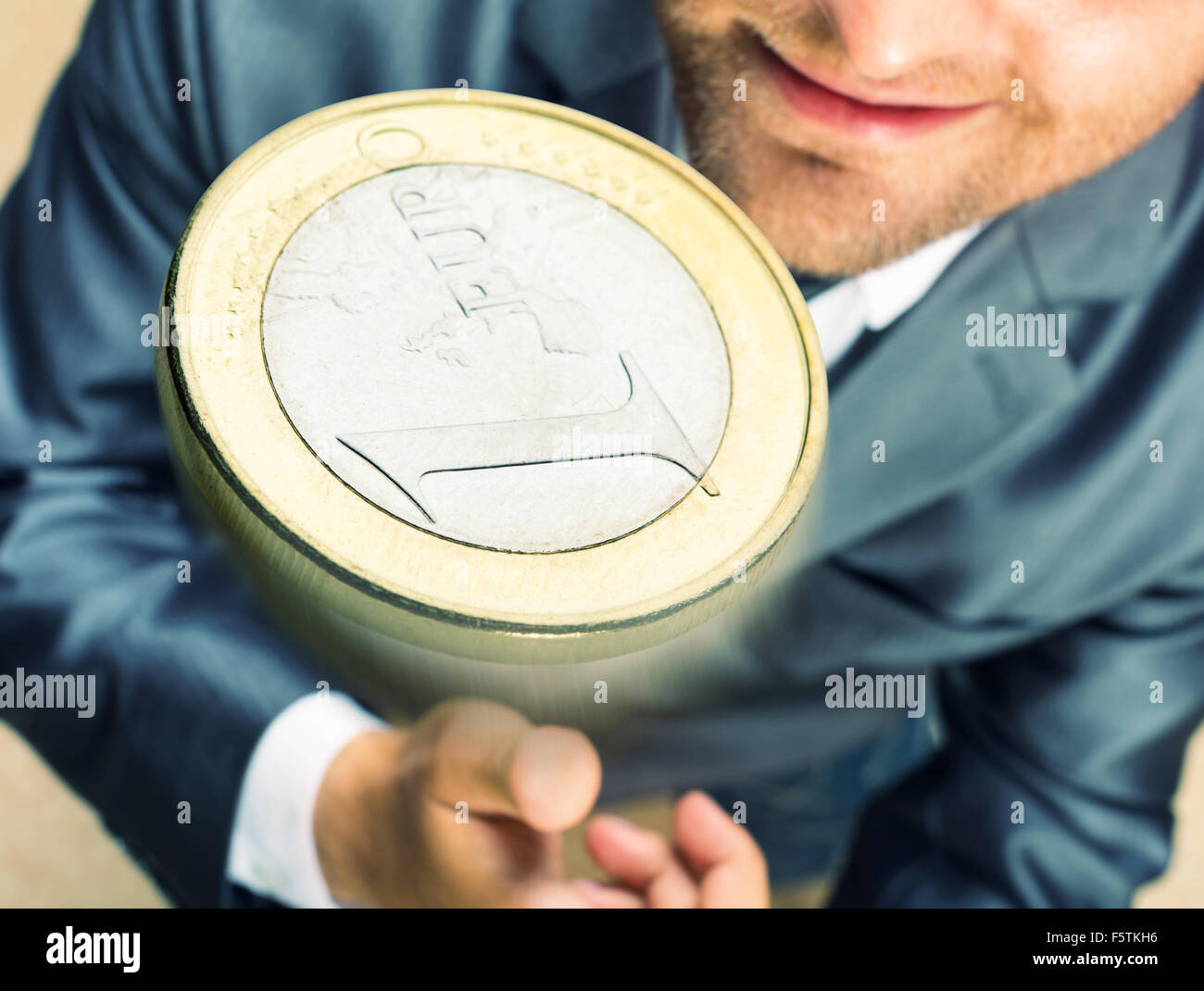Smiling businessman tossing a coin Stock Photo - Alamy