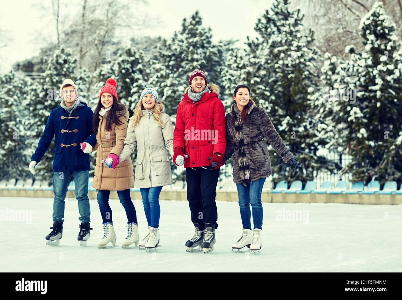 happy friends ice skating on rink outdoors Stock Photo - Alamy