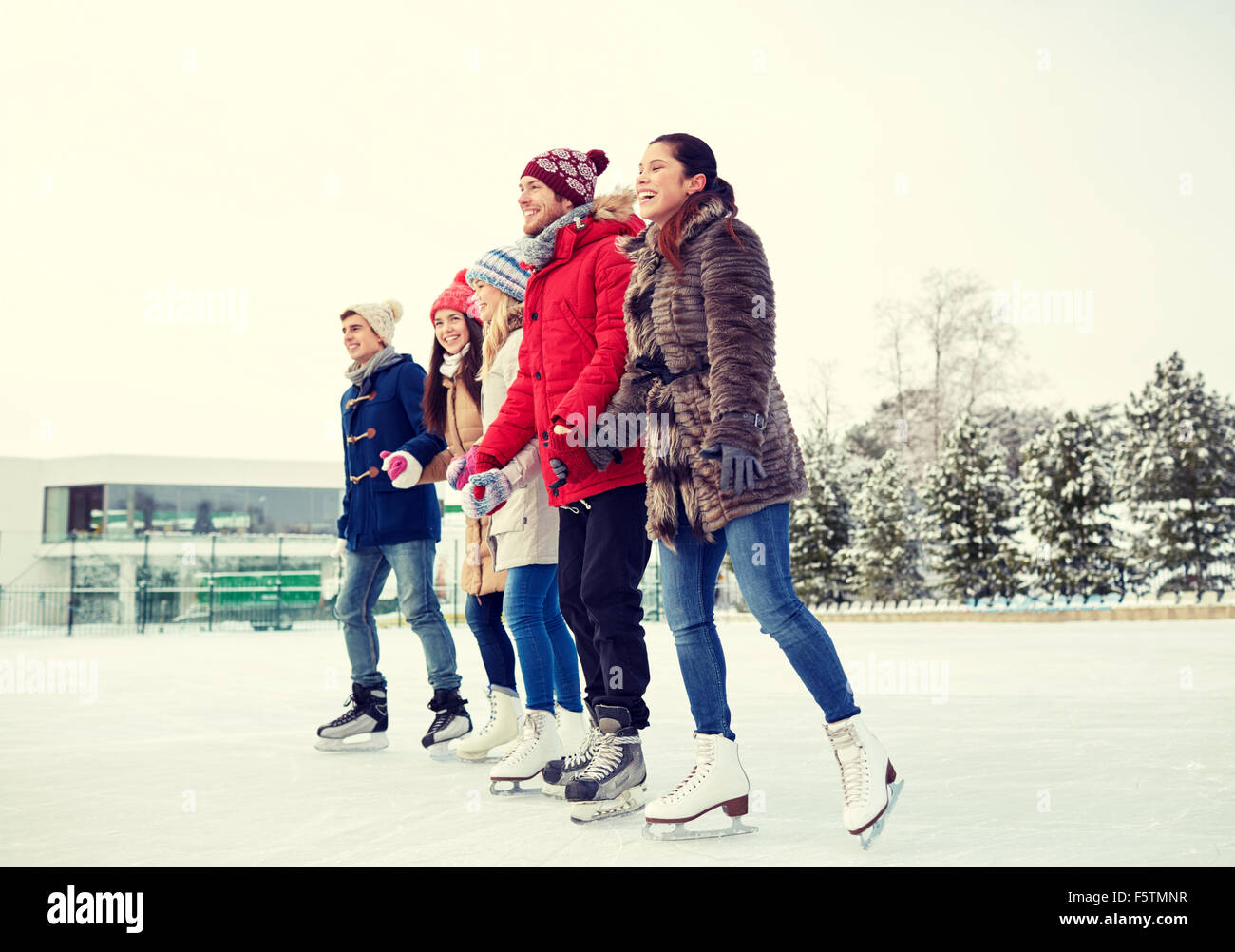happy friends ice skating on rink outdoors Stock Photo - Alamy