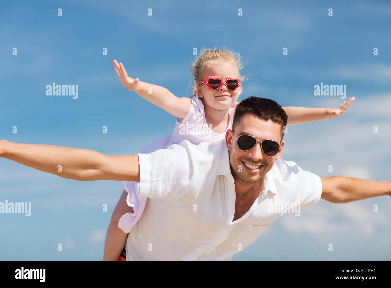 happy family having fun over blue sky background Stock Photo - Alamy