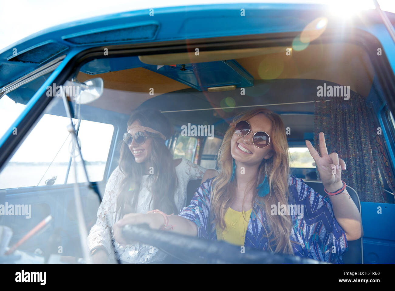 smiling young hippie women driving minivan car Stock Photo - Alamy