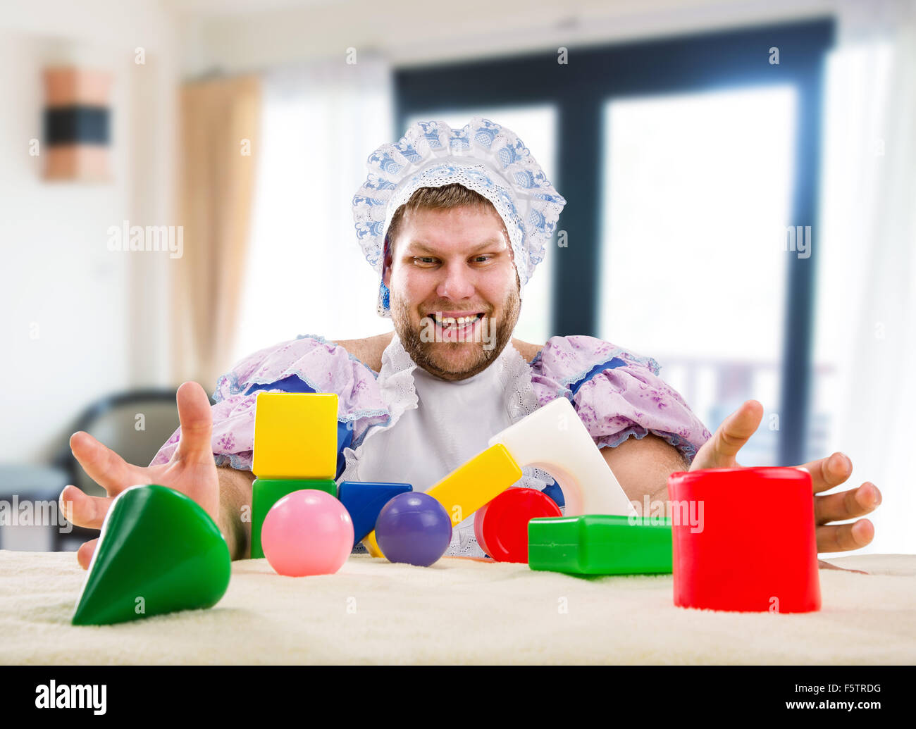 Man weared as baby playing Stock Photo - Alamy