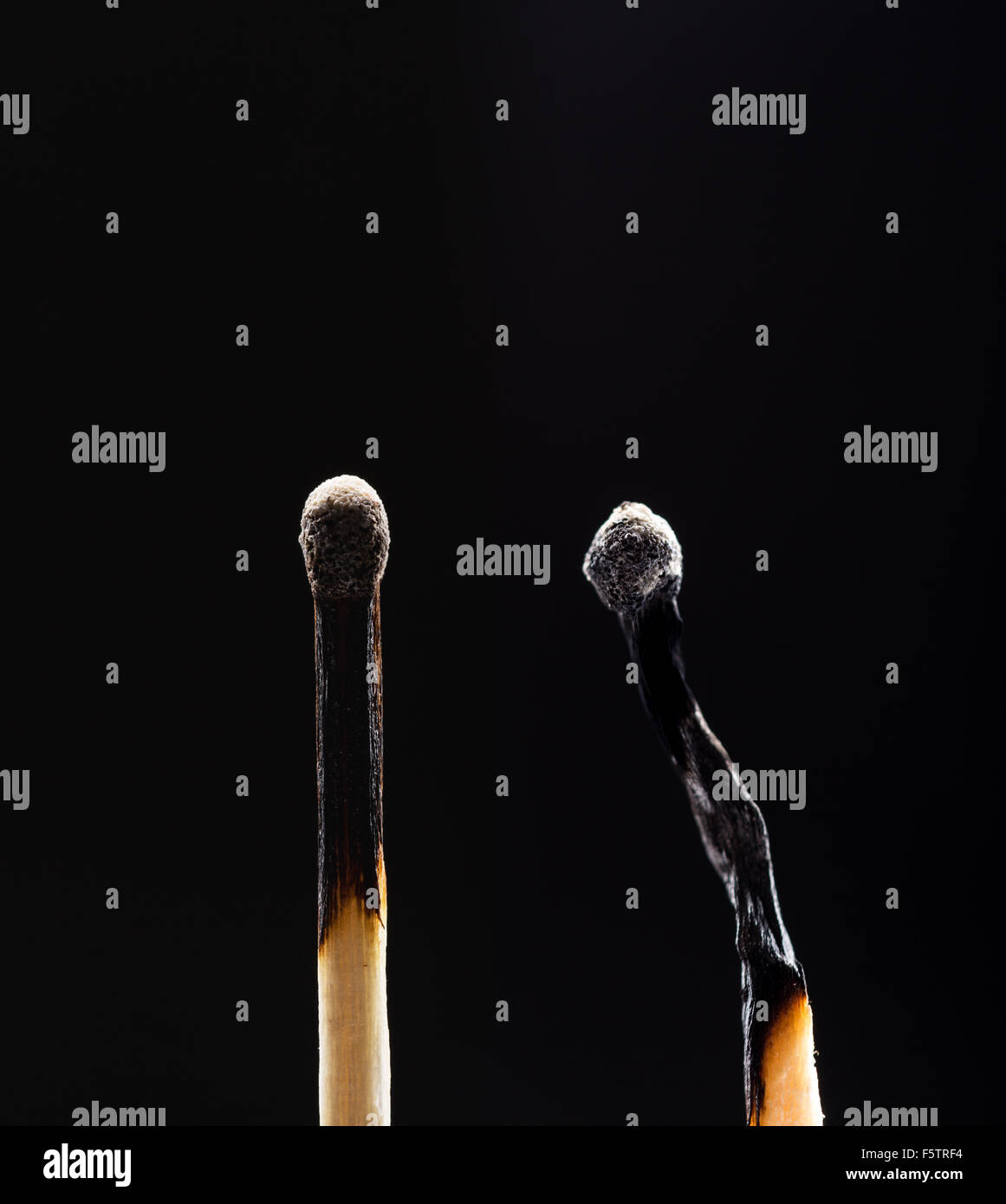 Two burned out wooden matches on black background Stock Photo - Alamy