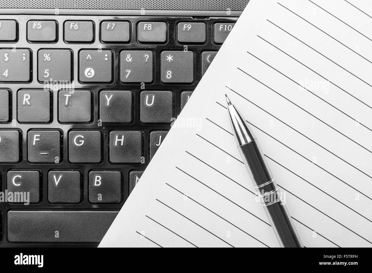 Notebook and pen on the black keyboard Stock Photo - Alamy