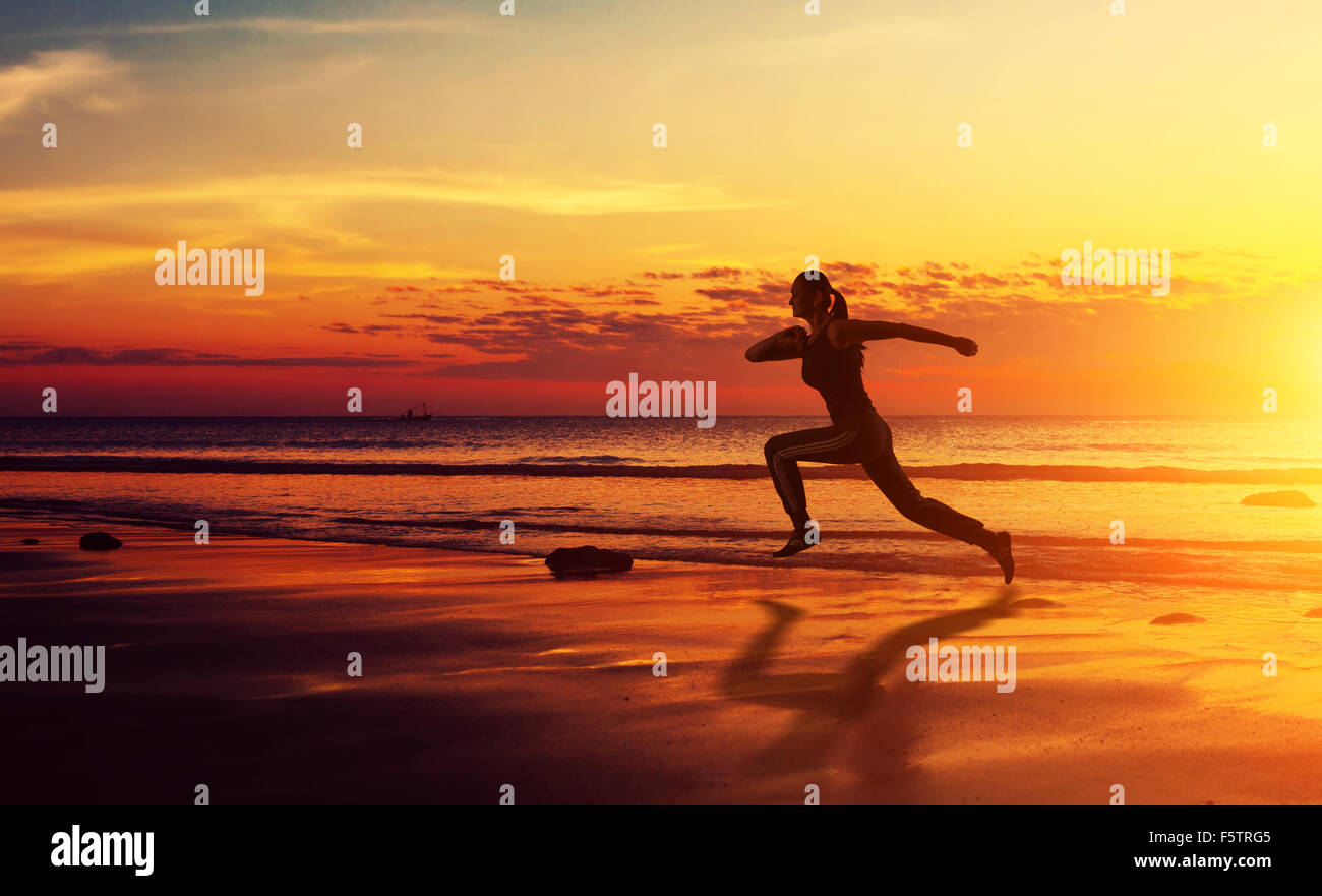 Healthy fitness woman running at sunset beach Stock Photo - Alamy