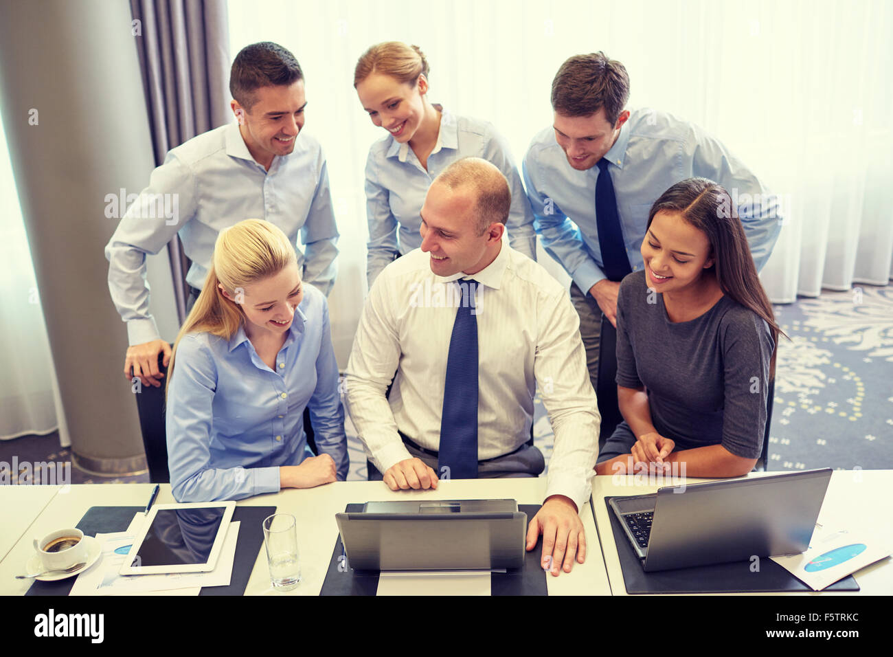 smiling business people with laptop in office Stock Photo - Alamy