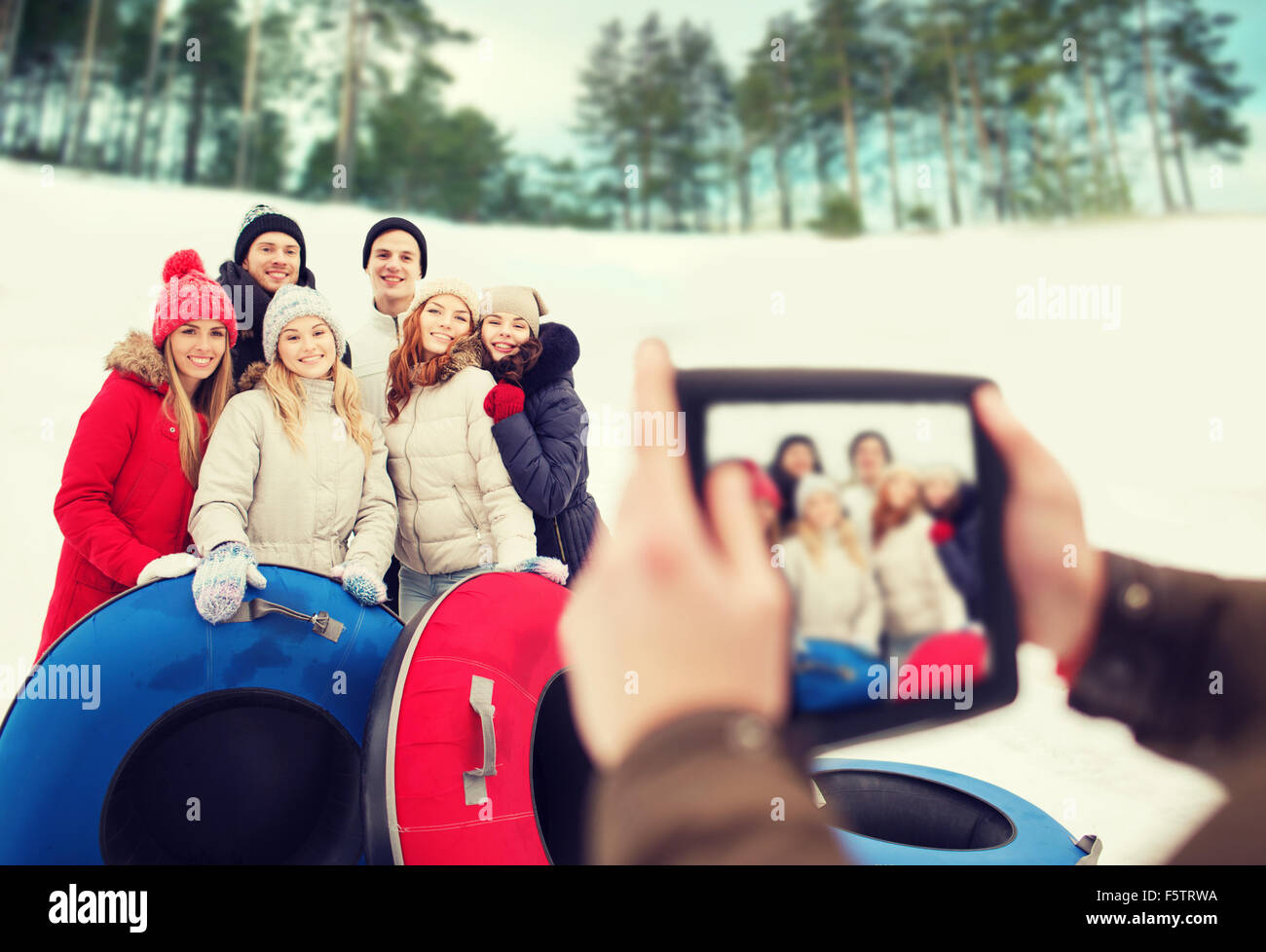group of smiling friends with snow tubes Stock Photo - Alamy