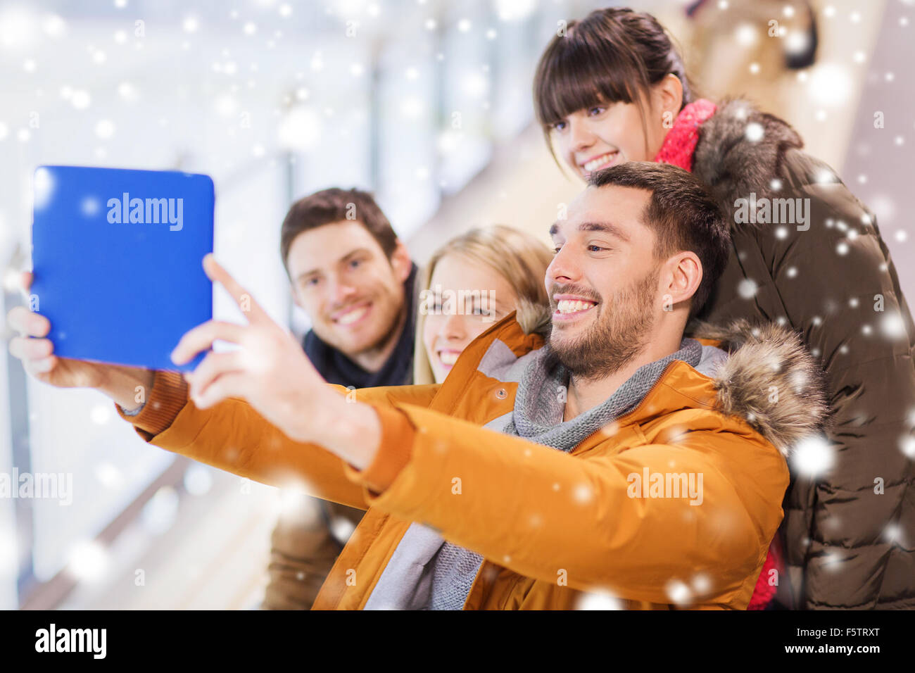 happy friends with tablet pc on skating rink Stock Photo - Alamy