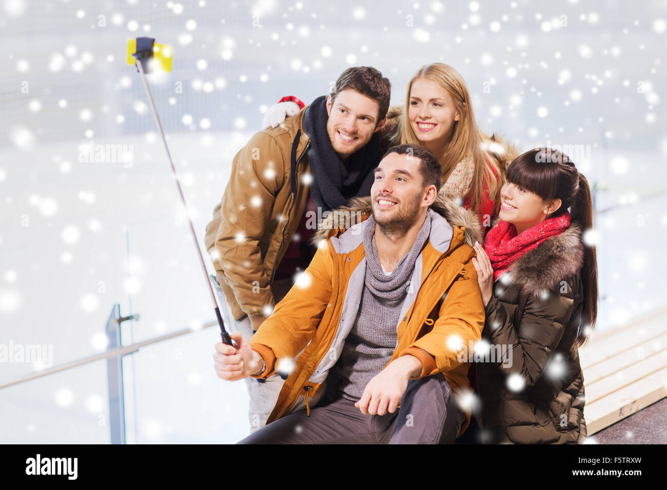 happy friends with smartphone on skating rink Stock Photo - Alamy