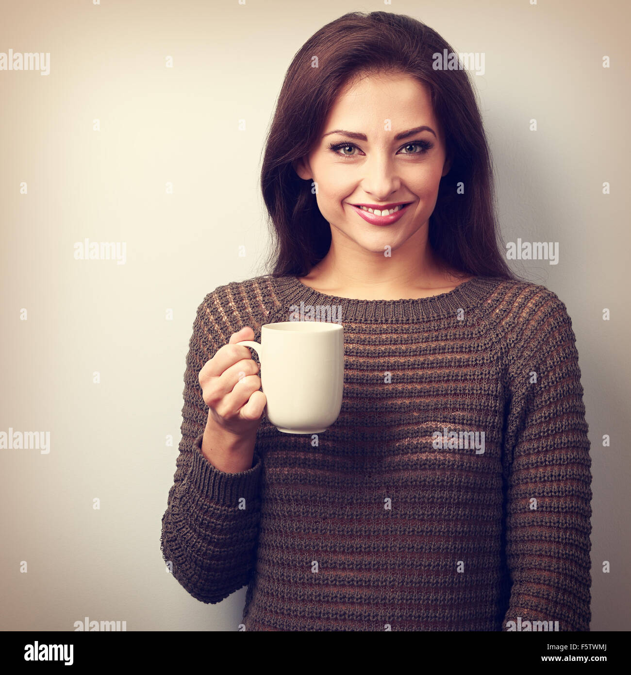 Smiling casual young woman with cup of tea looking happy. Vintage ...