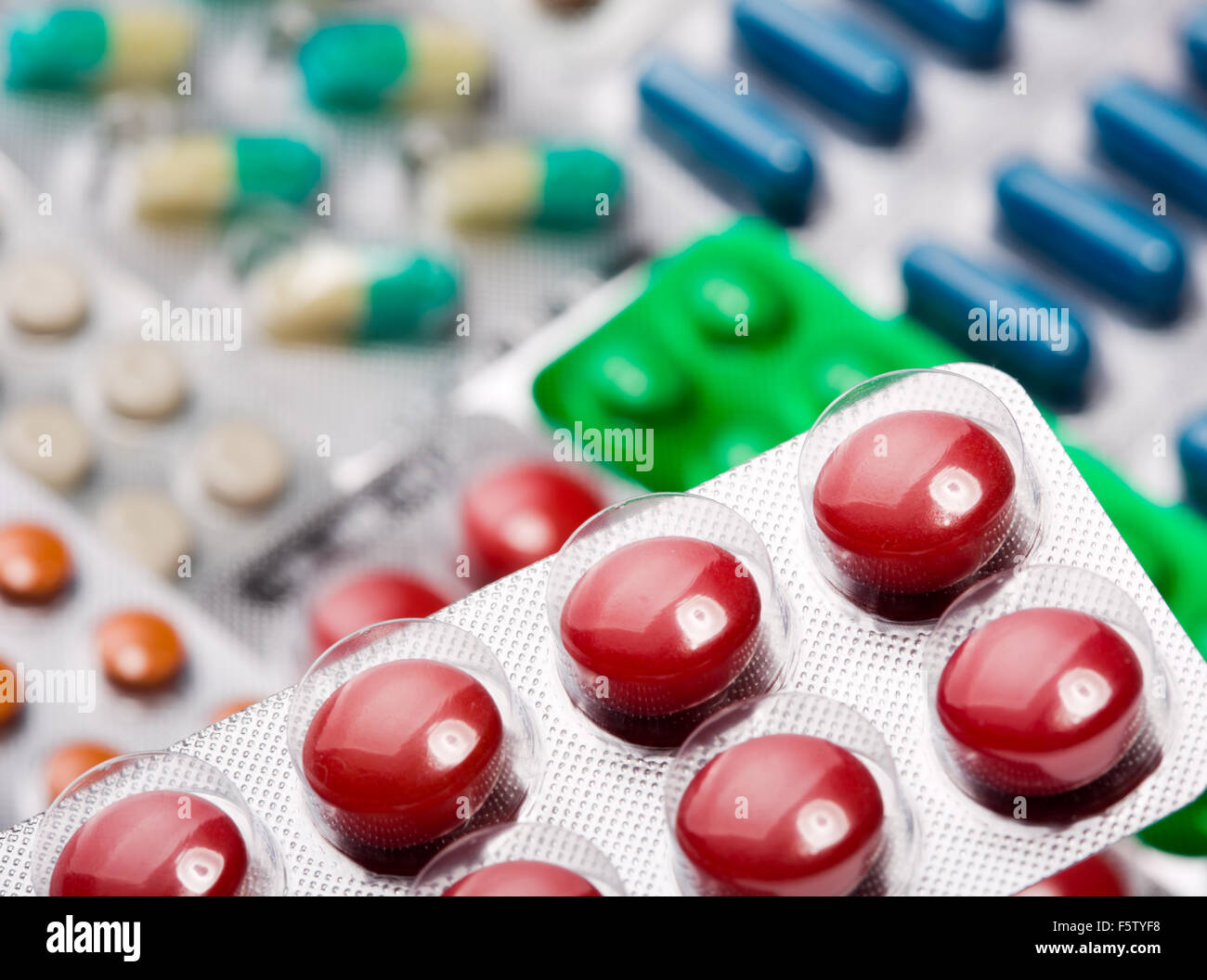 Plate of red pills with various colorful medicines on background Stock ...