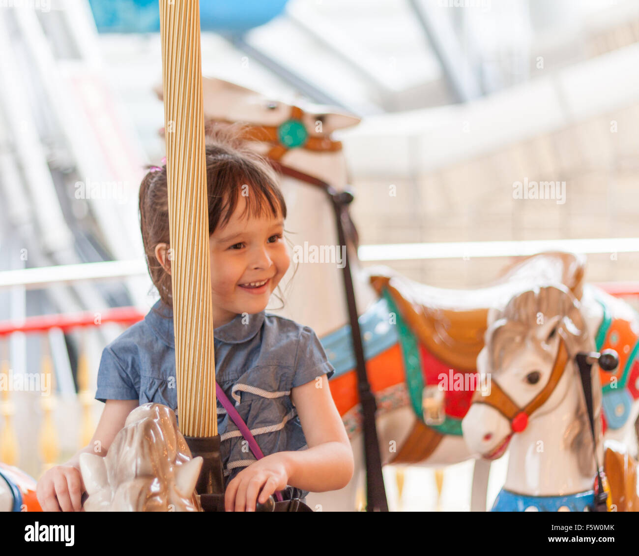 Young girl riding carousel horse at amusement park Stock Photo - Alamy