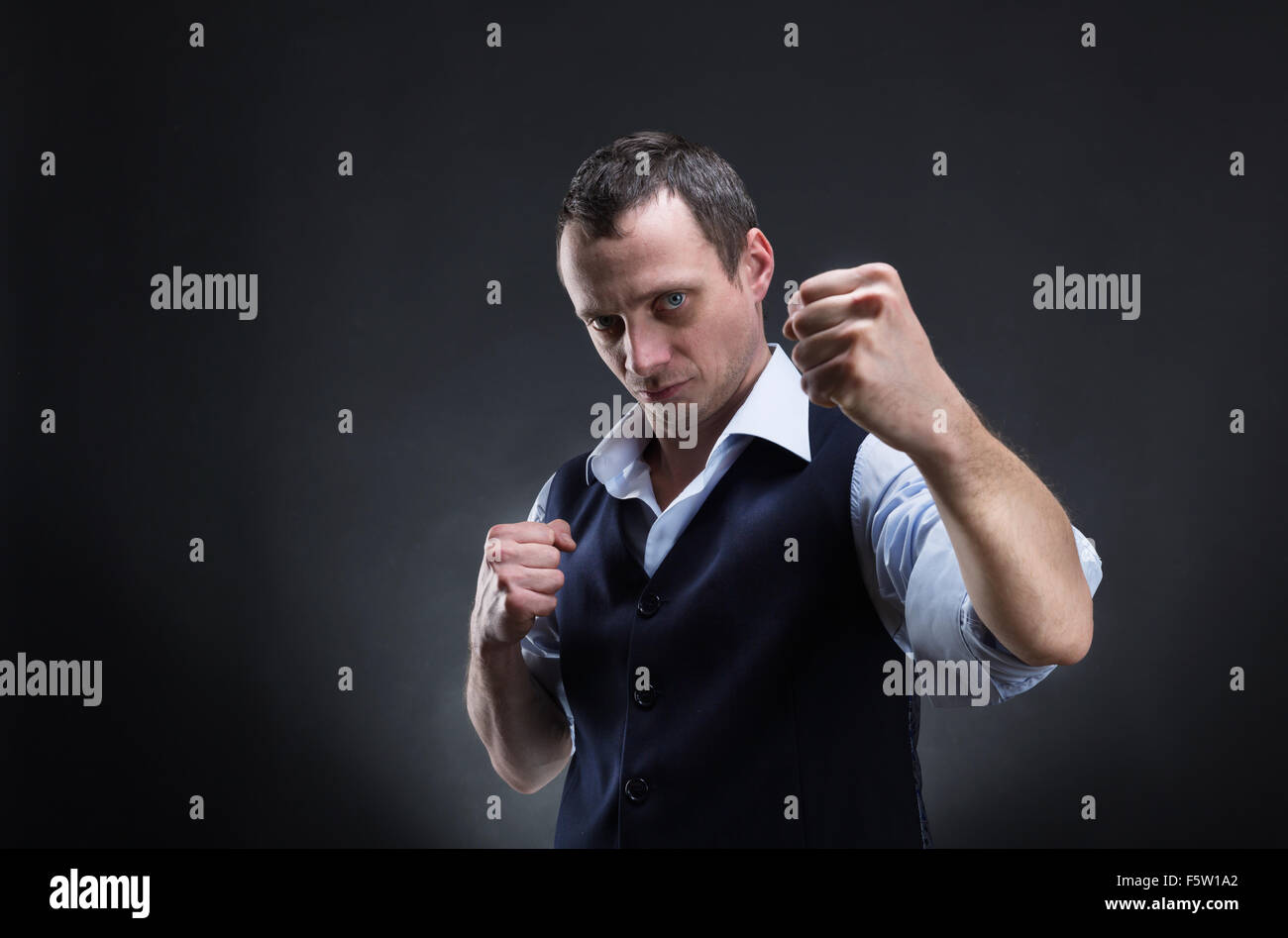 Fighting businessman over grey background Stock Photo - Alamy