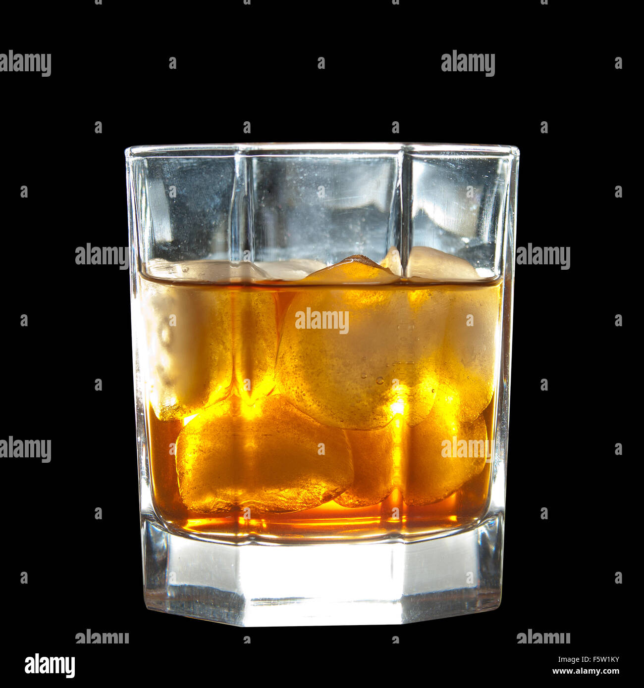 Gold whiskey on the rocks. Isolated on black Stock Photo - Alamy