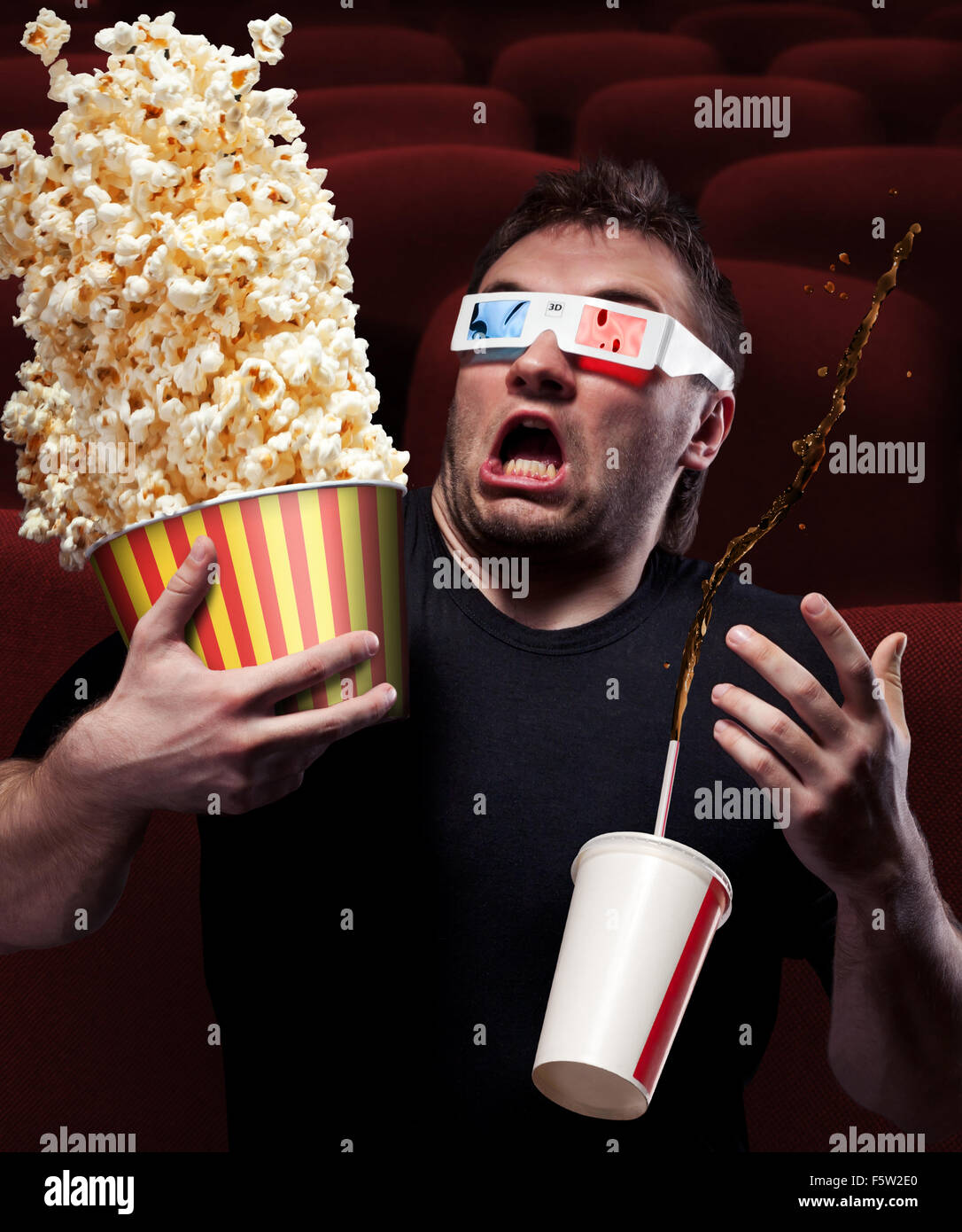 Portrait of very scared man watching 3D movie, drinking cola and eating popcorn Stock Photo - Alamy