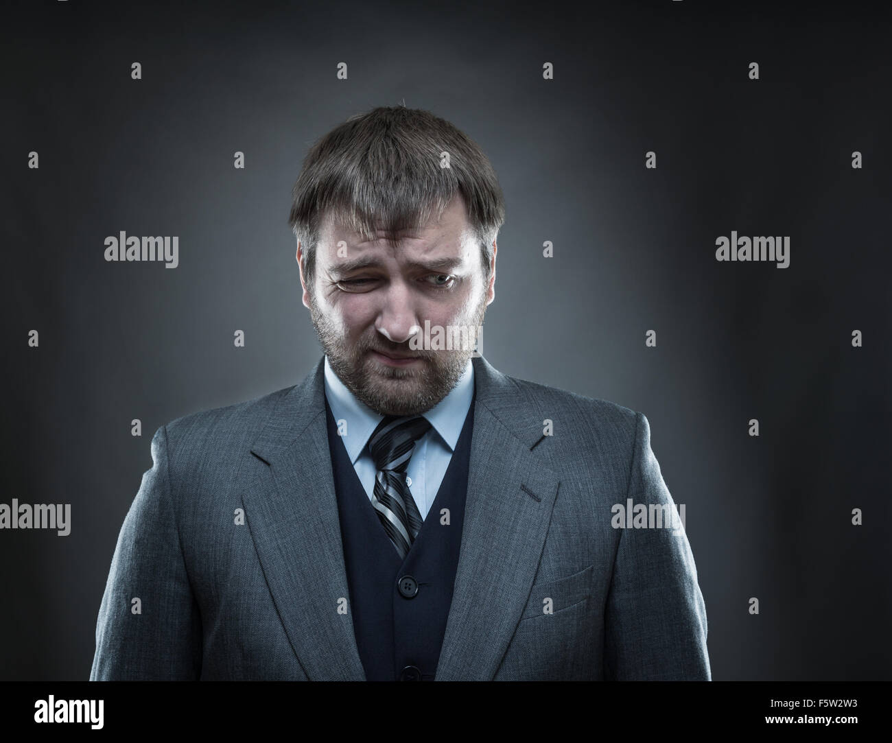 Sad businessman agaist dark gray background Stock Photo - Alamy