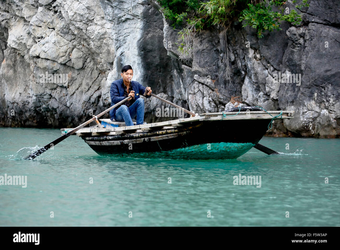 Man rowing wooden rowboat, Vung Vieng fishing village, Ha Long Bay, Bai ...