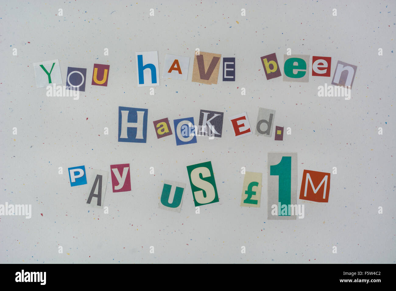 Cut-out letters making up a ransomware message demand on a rough type ...