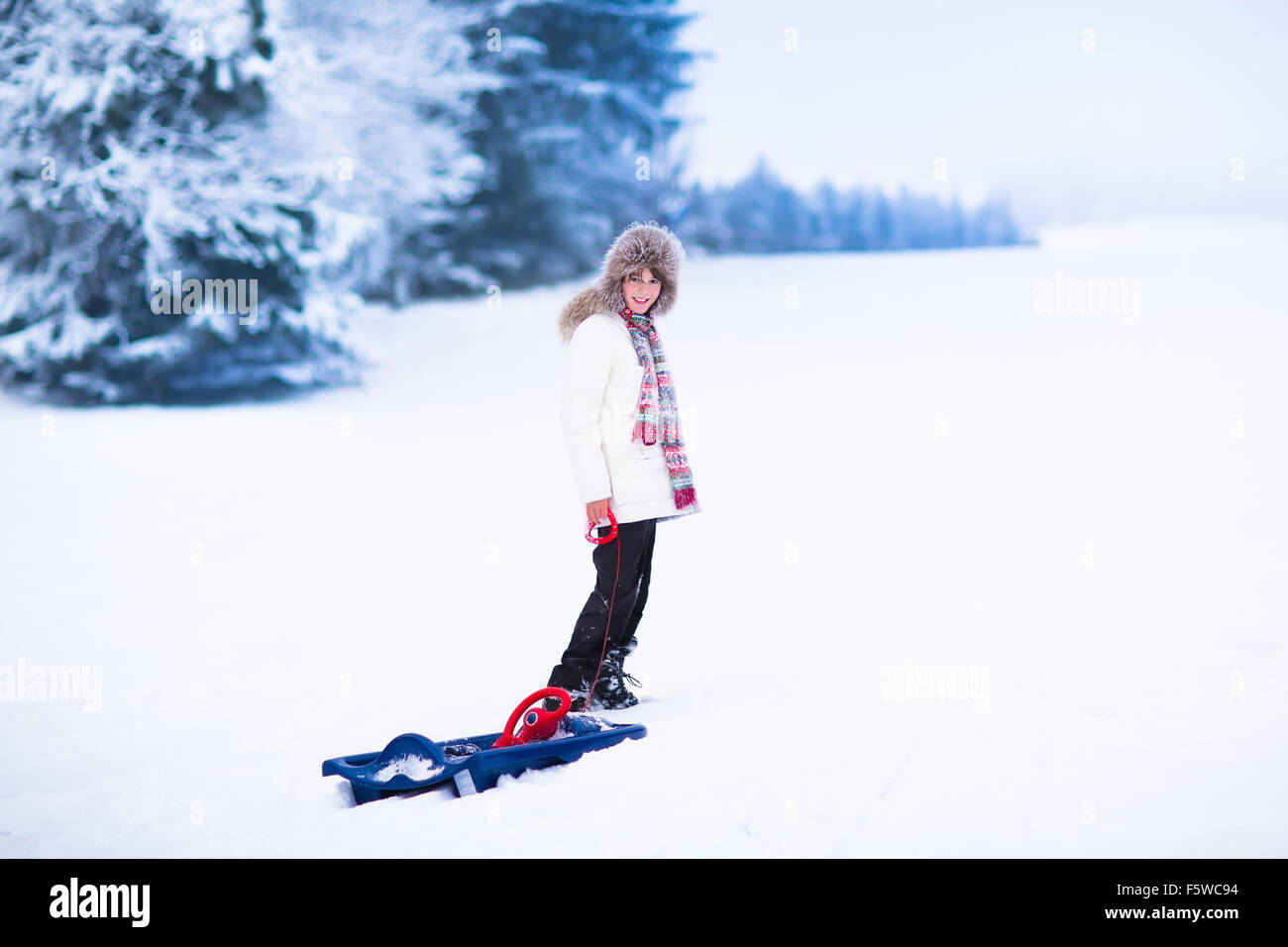 Happy child enjoying a sleigh ride. Child sledding. School kid riding a ...