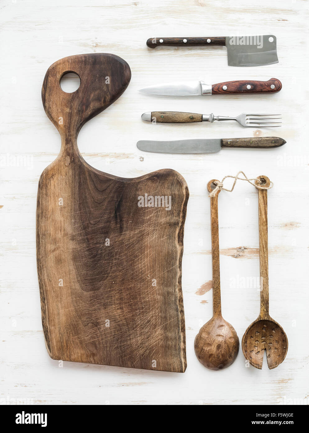 Kitchen-ware set. Old rustic chopping board made of walnut wood, knives ...
