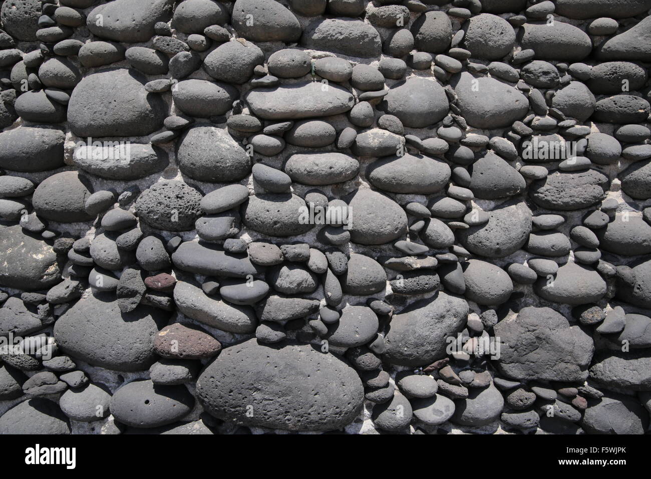 Wall constructed from pebbles repeating pattern hi-res stock ...