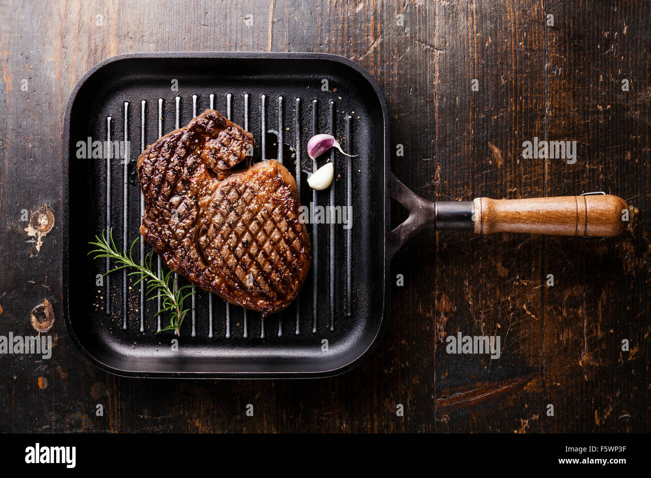 Grilled Black Angus Steak Ribeye with garlic and rosemary on grill pan ...