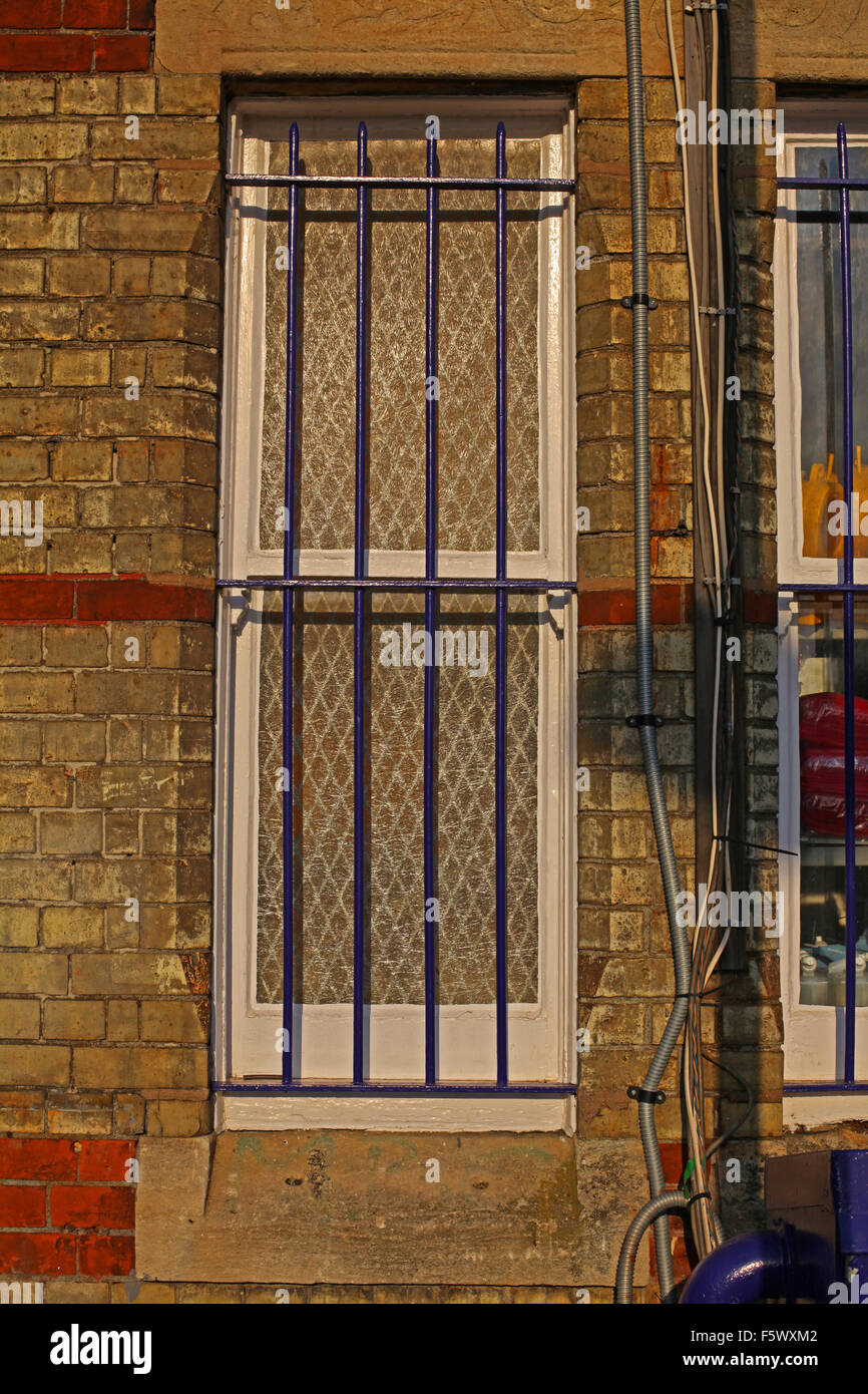 An obscured glass window with armoured screen inside and steel bars ...