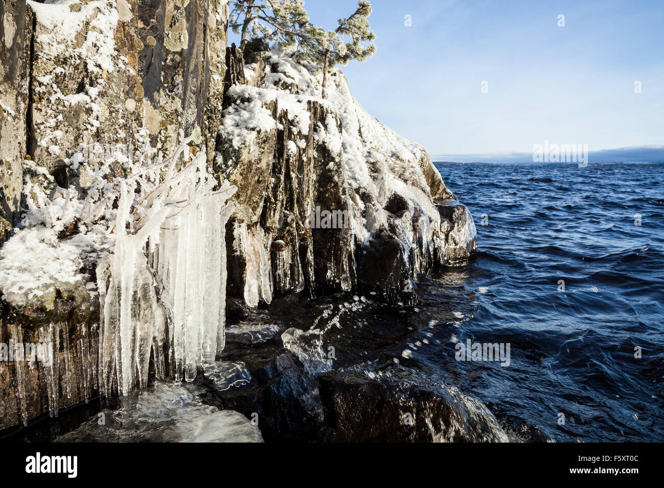 Frozen lakefront rock cliff Stock Photo - Alamy