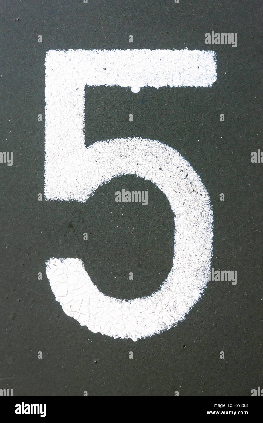 Number five stencilled, white paint on dark grey Stock Photo - Alamy