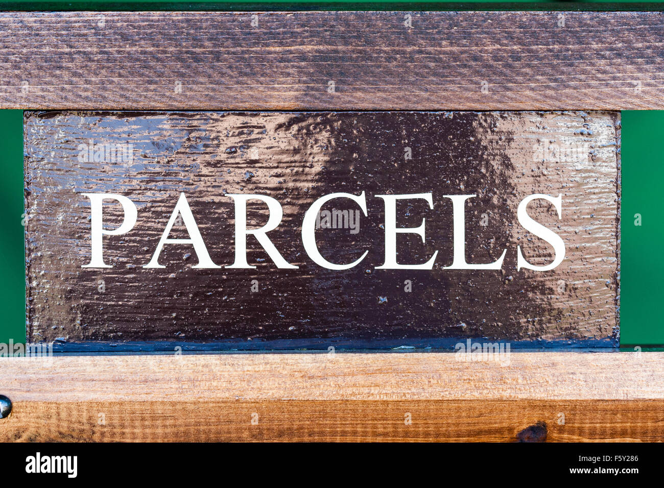 Sign, 'Parcels'. White lettering on dark vanished brass-plate with ...