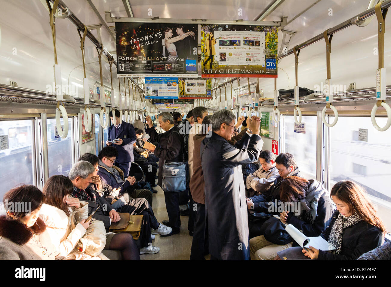 Japan, Osaka. Interior of Nankai railway crowded commuter train with ...