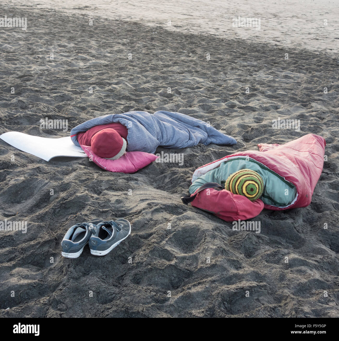 Two young backpackers sleeping on beach in Spain Stock Photo - Alamy