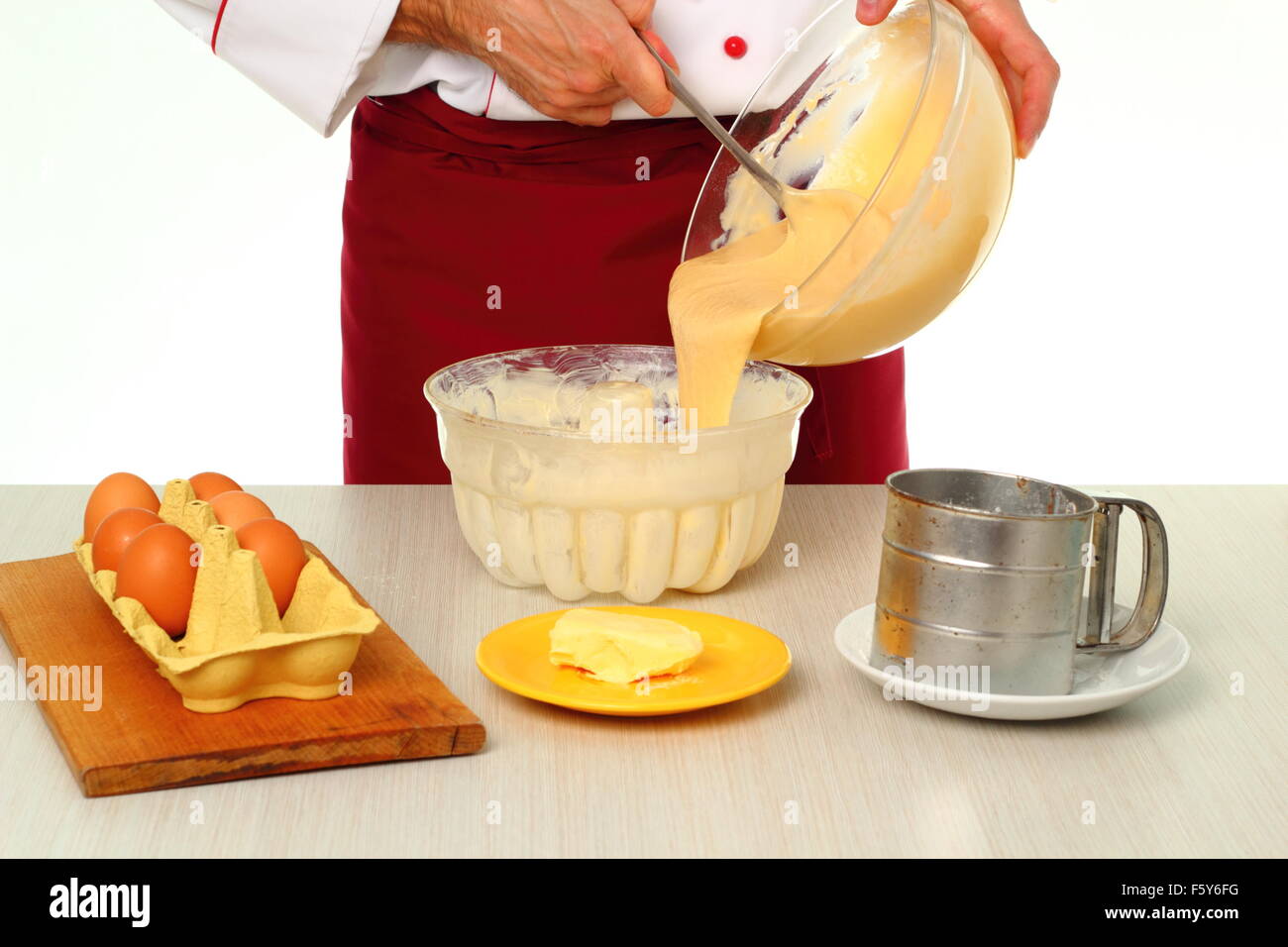 Pouring cake batter into baking pan. Making bundt cake with chocolate ...