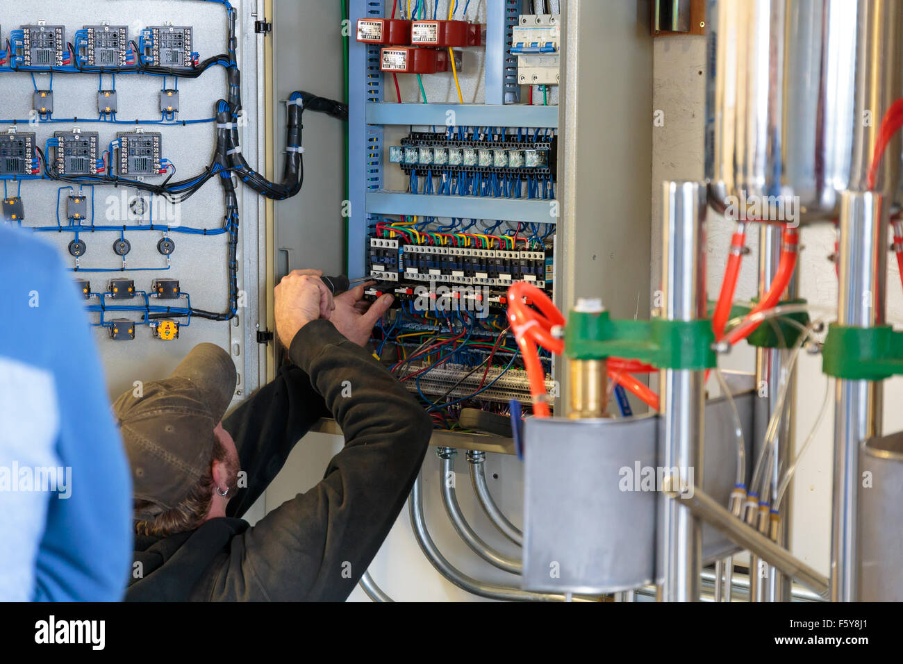 EUGENE, OR - NOVEMBER 4, 2015: Electrician working on an electrical ...