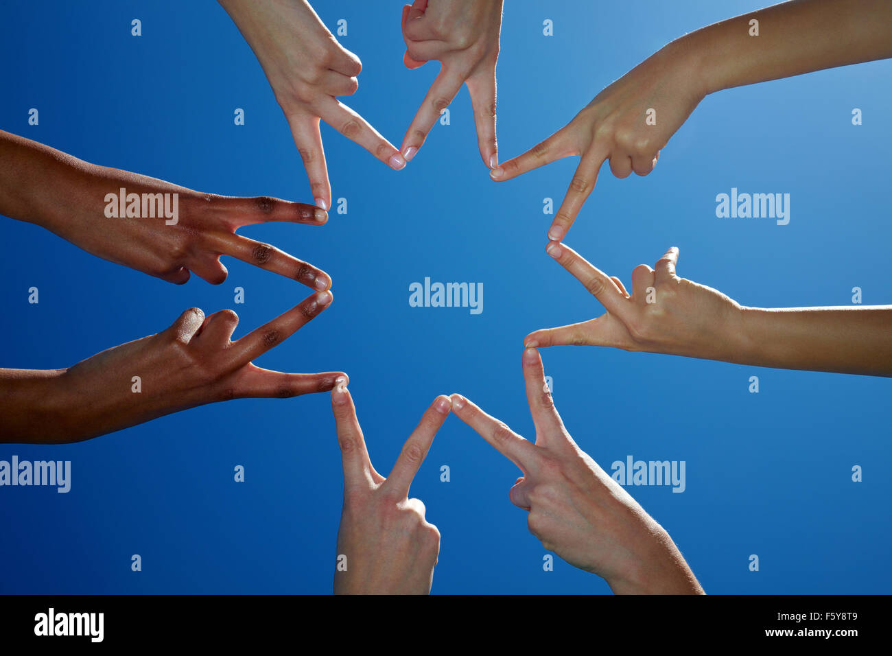 Eight hands form a star with their fingers Stock Photo - Alamy