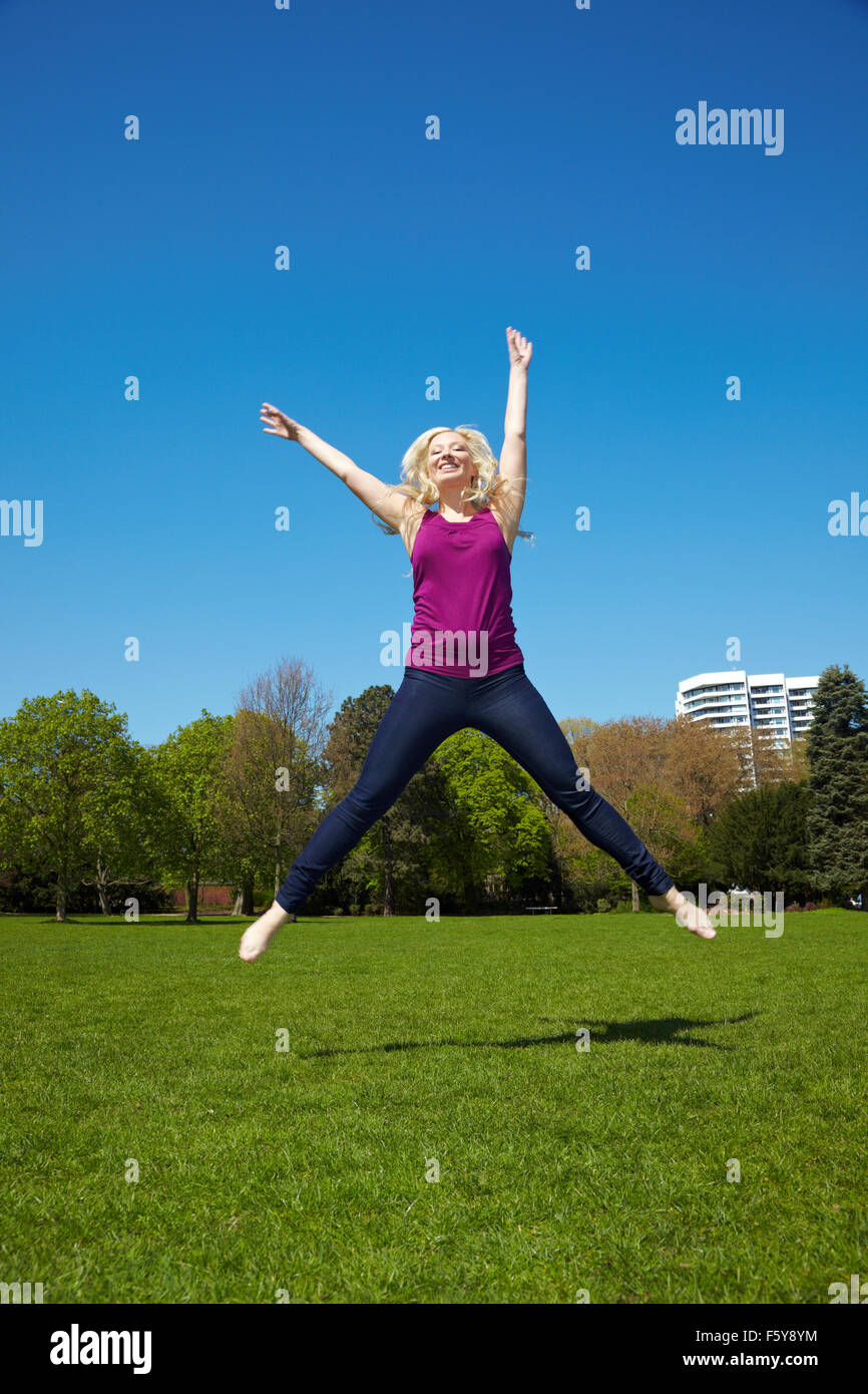 Happy young woman jumping into the air Stock Photo - Alamy