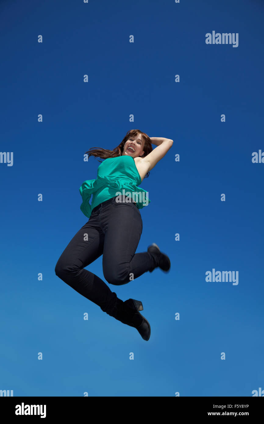 Happy young woman jumping into the air Stock Photo - Alamy