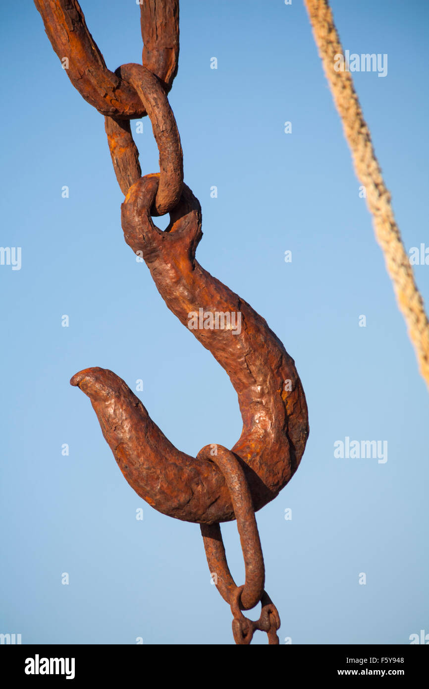 rusty hook with hanging chain with rope and blue sky behind Stock Photo ...