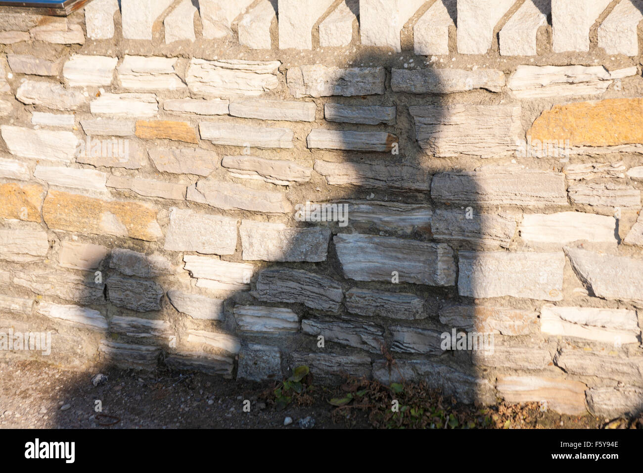 Shadow of two people against stone wall Stock Photo - Alamy