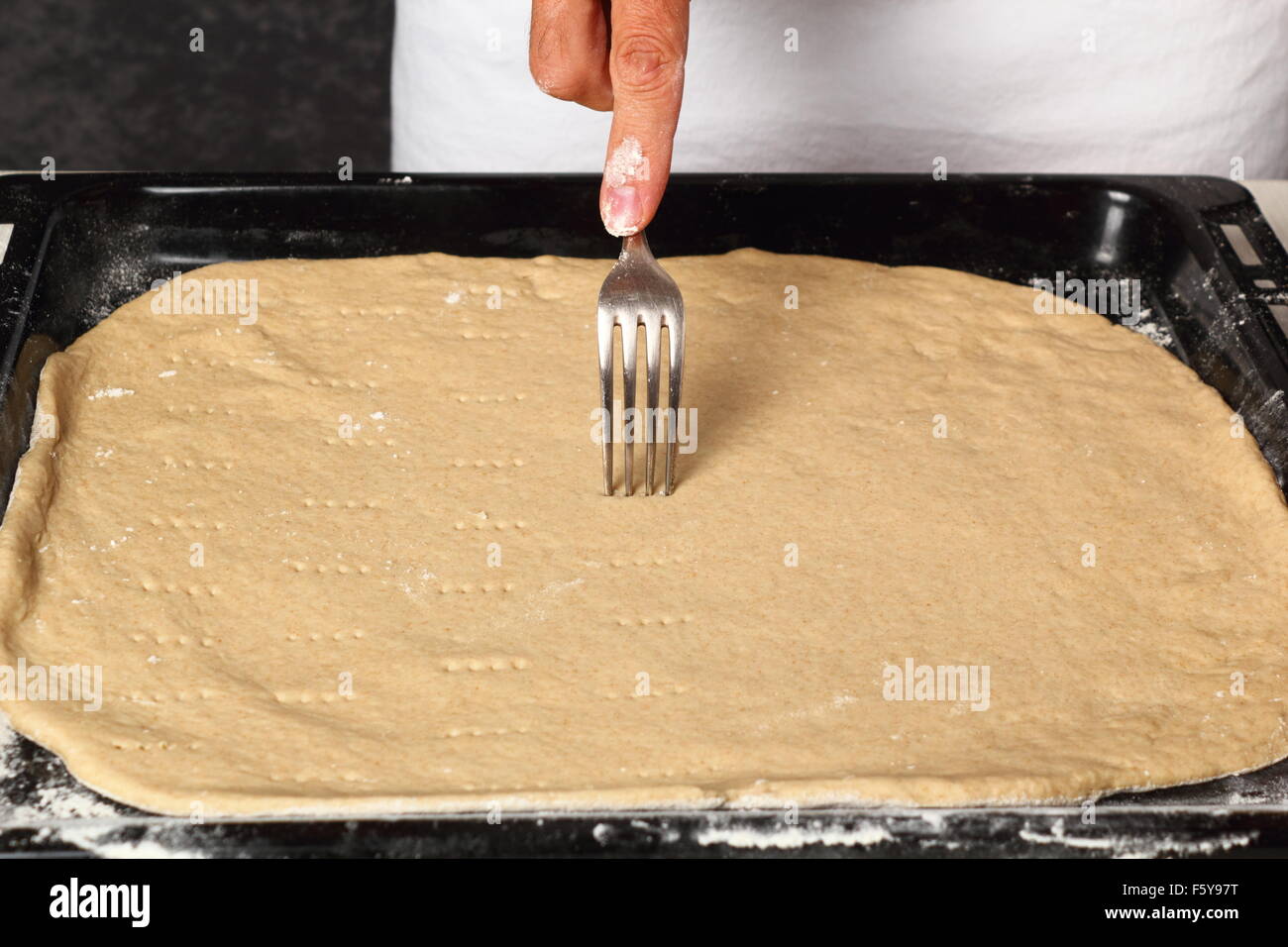 Pricking dough with fork. Making Flatbread Stock Photo - Alamy